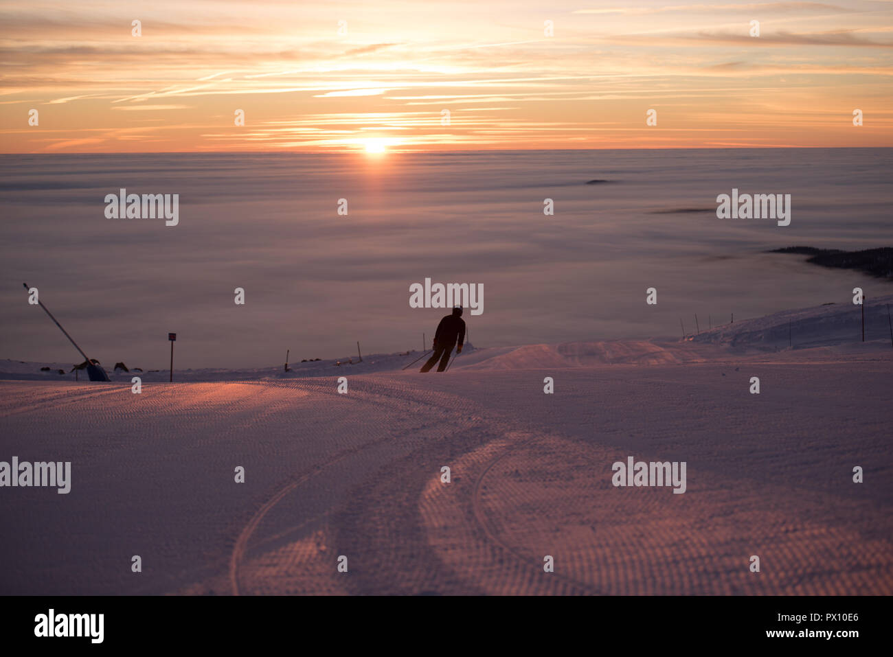 Winter ski holiday in snowy mountains with beautiful glowing red sun ...