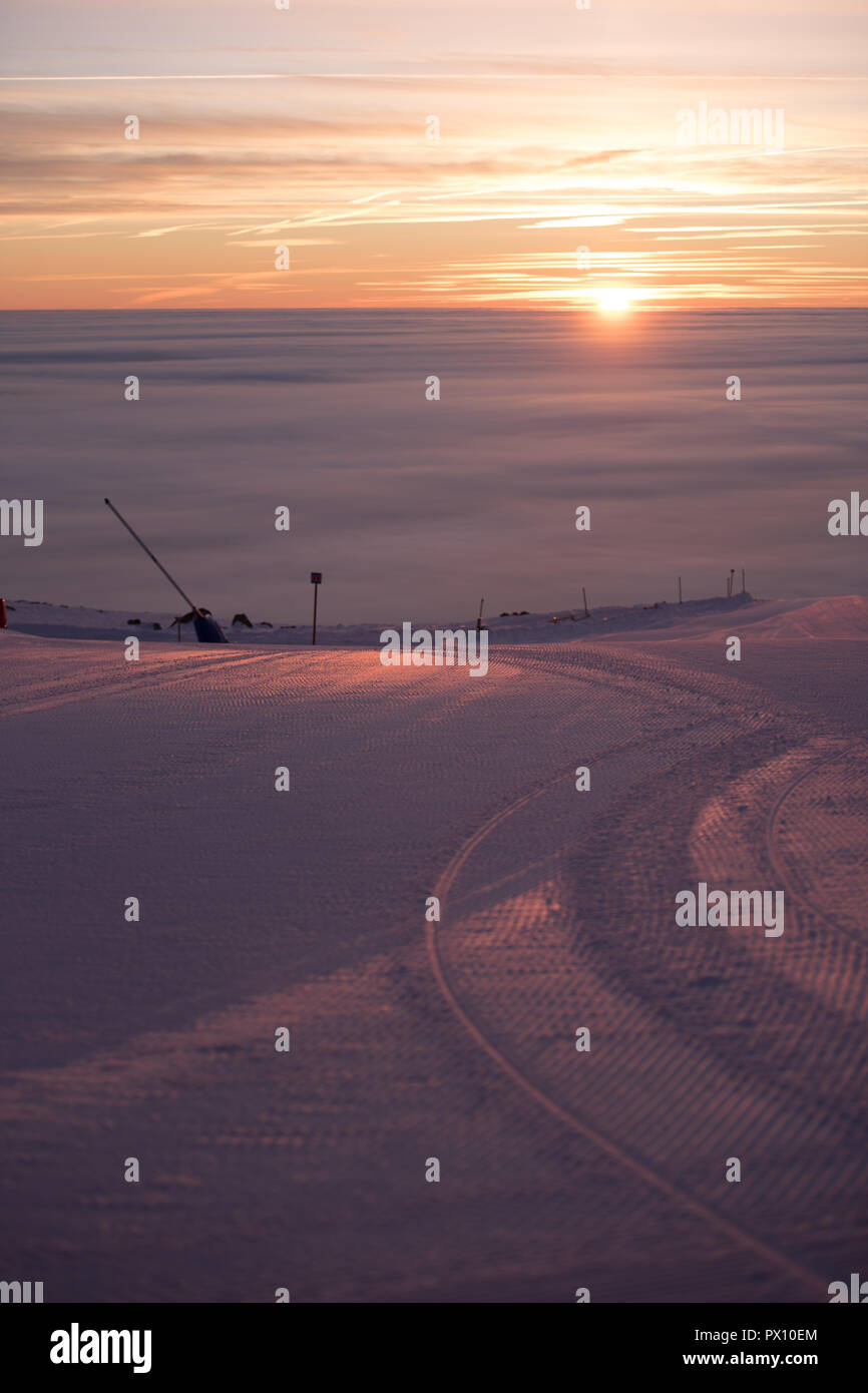 Winter ski holiday in snowy mountains with beautiful glowing red sun ...