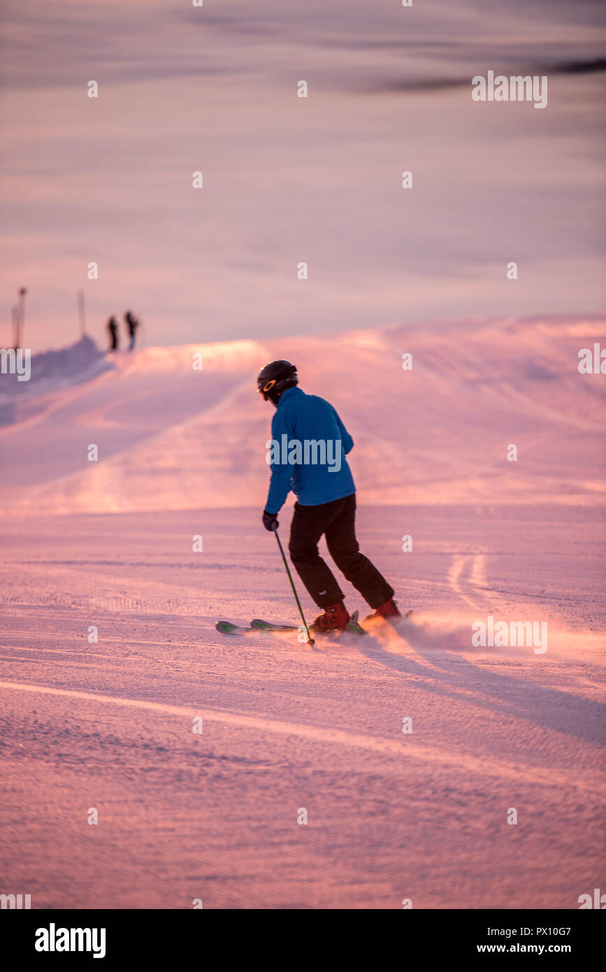 Winter ski holiday in snowy mountains with beautiful glowing red sun ...
