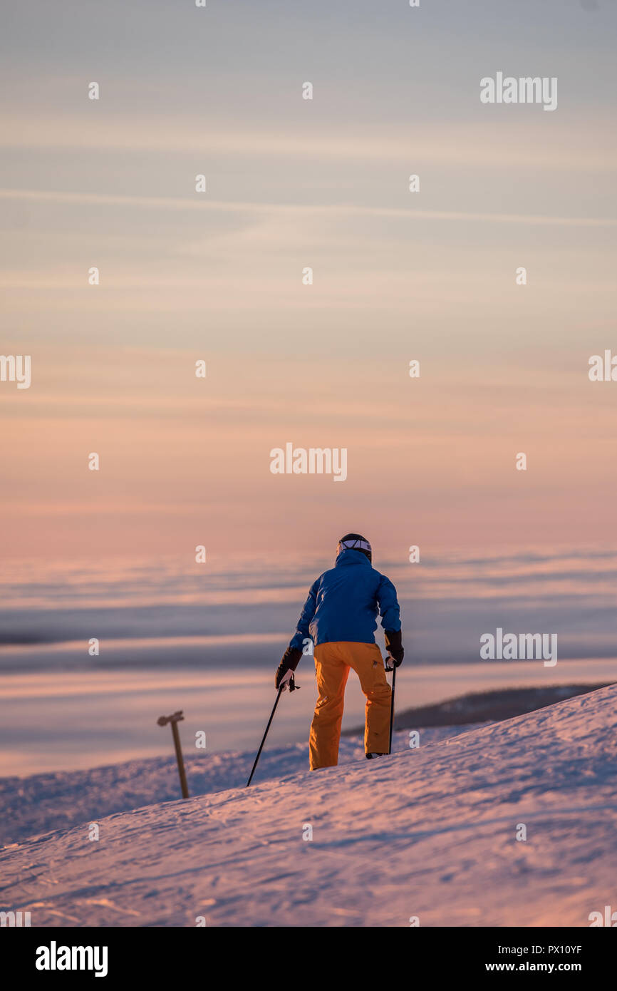 Winter ski holiday in snowy mountains with beautiful glowing red sun ...