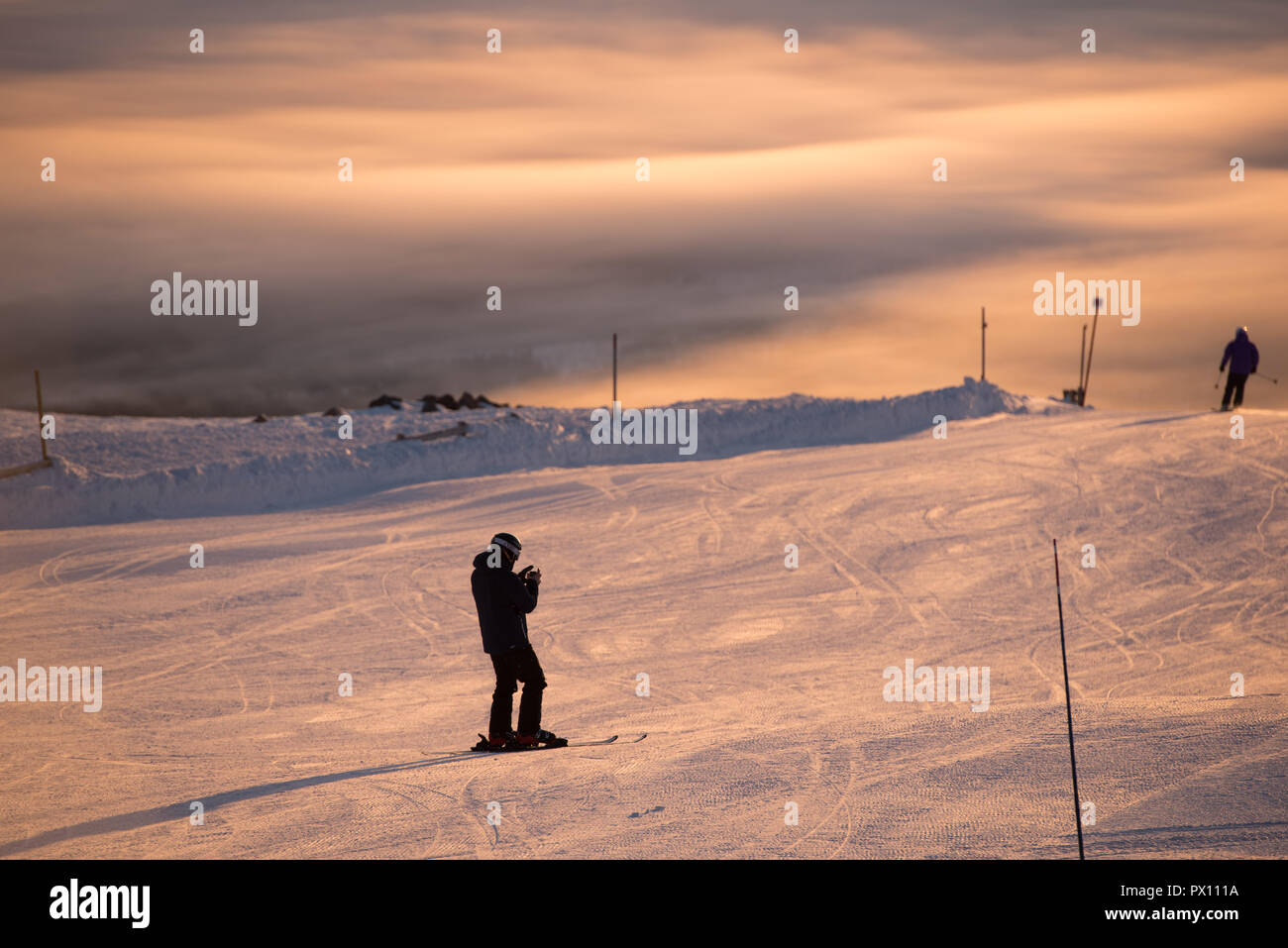Winter ski holiday in snowy mountains with beautiful glowing red sun ...