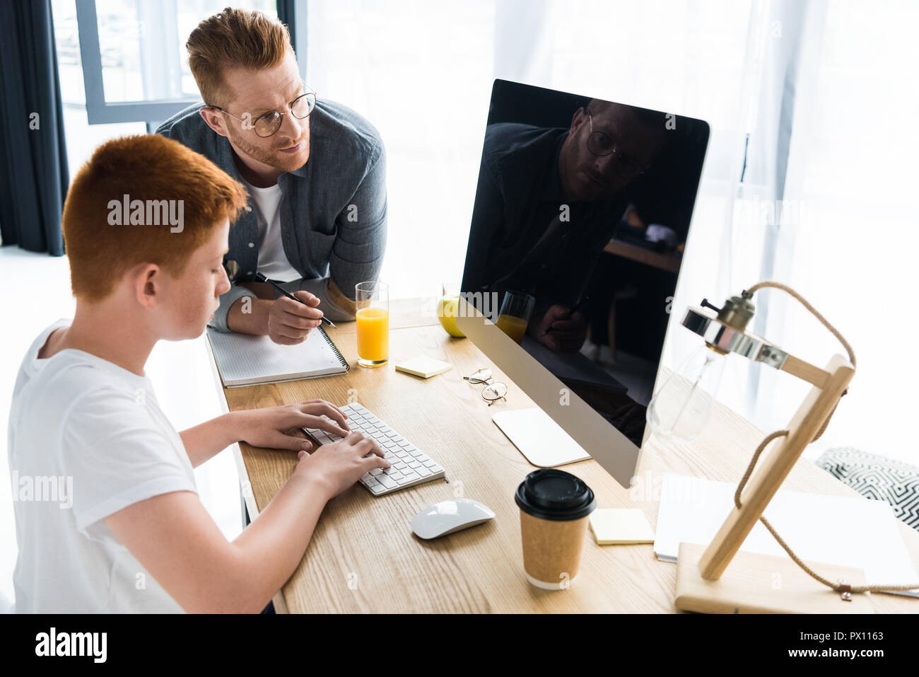 ginger hair father and son looking at computer at home Stock Photo - Alamy