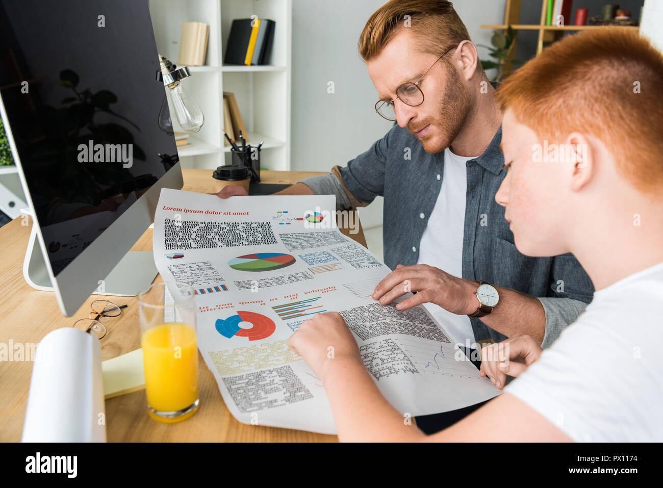 father and son looking at diagram at table at home Stock Photo - Alamy