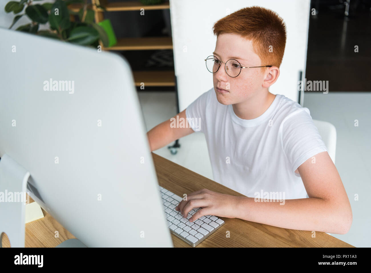 preteen ginger hair boy using computer in room Stock Photo - Alamy