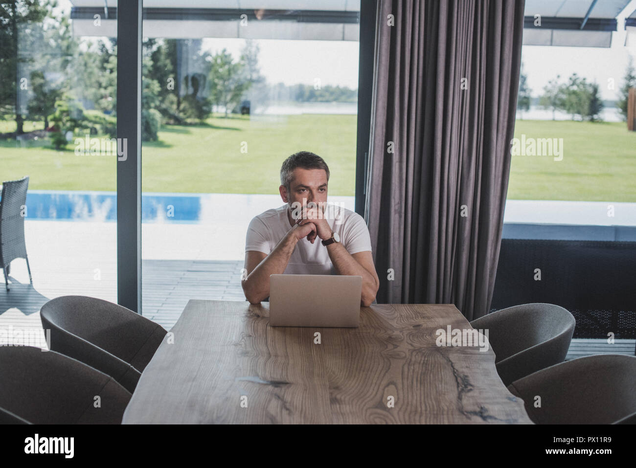 Thoughtful man sitting table laptop hi-res stock photography and images ...