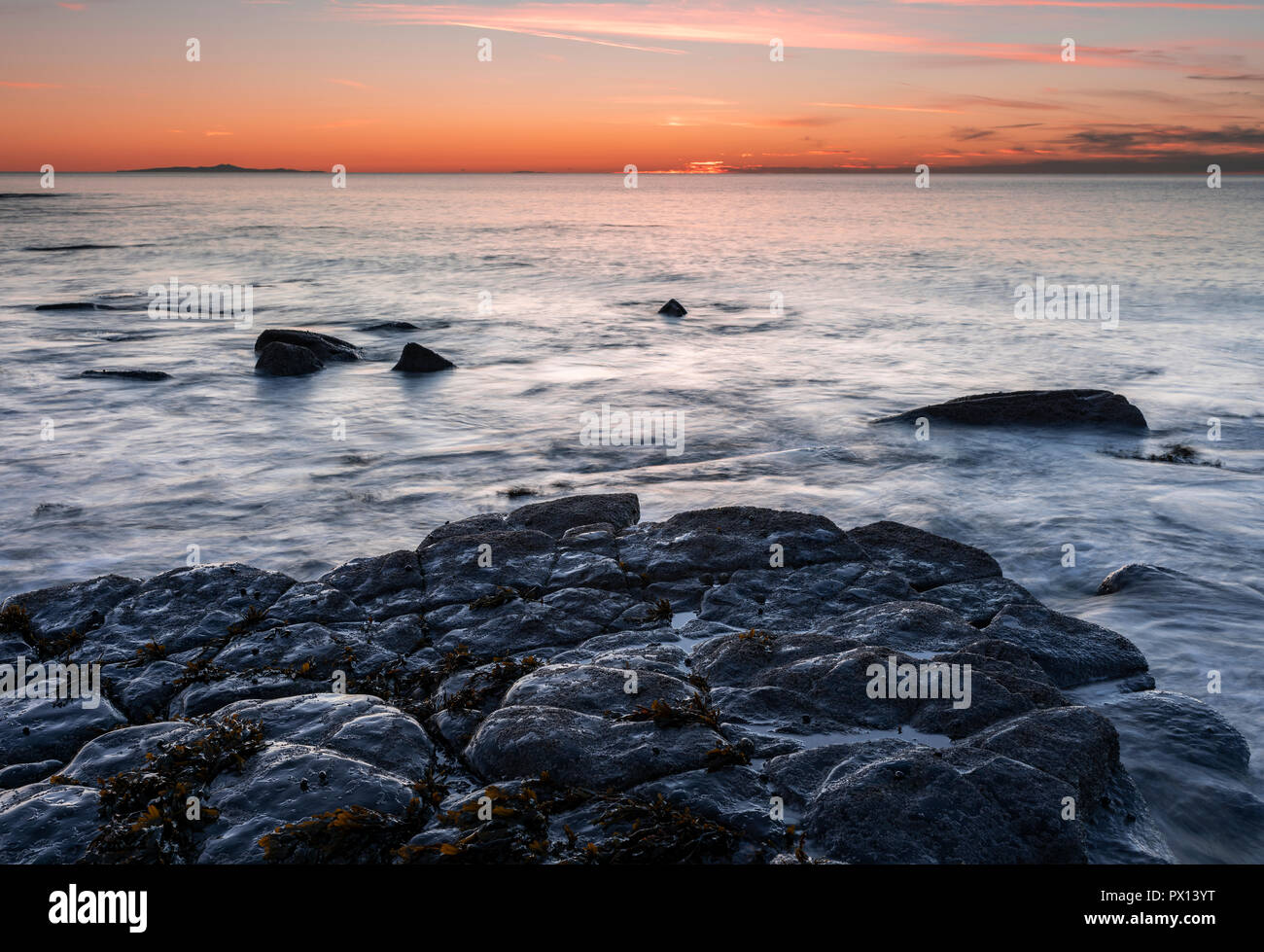 Sunset colours off the rugged Cumbrian coast Stock Photo - Alamy