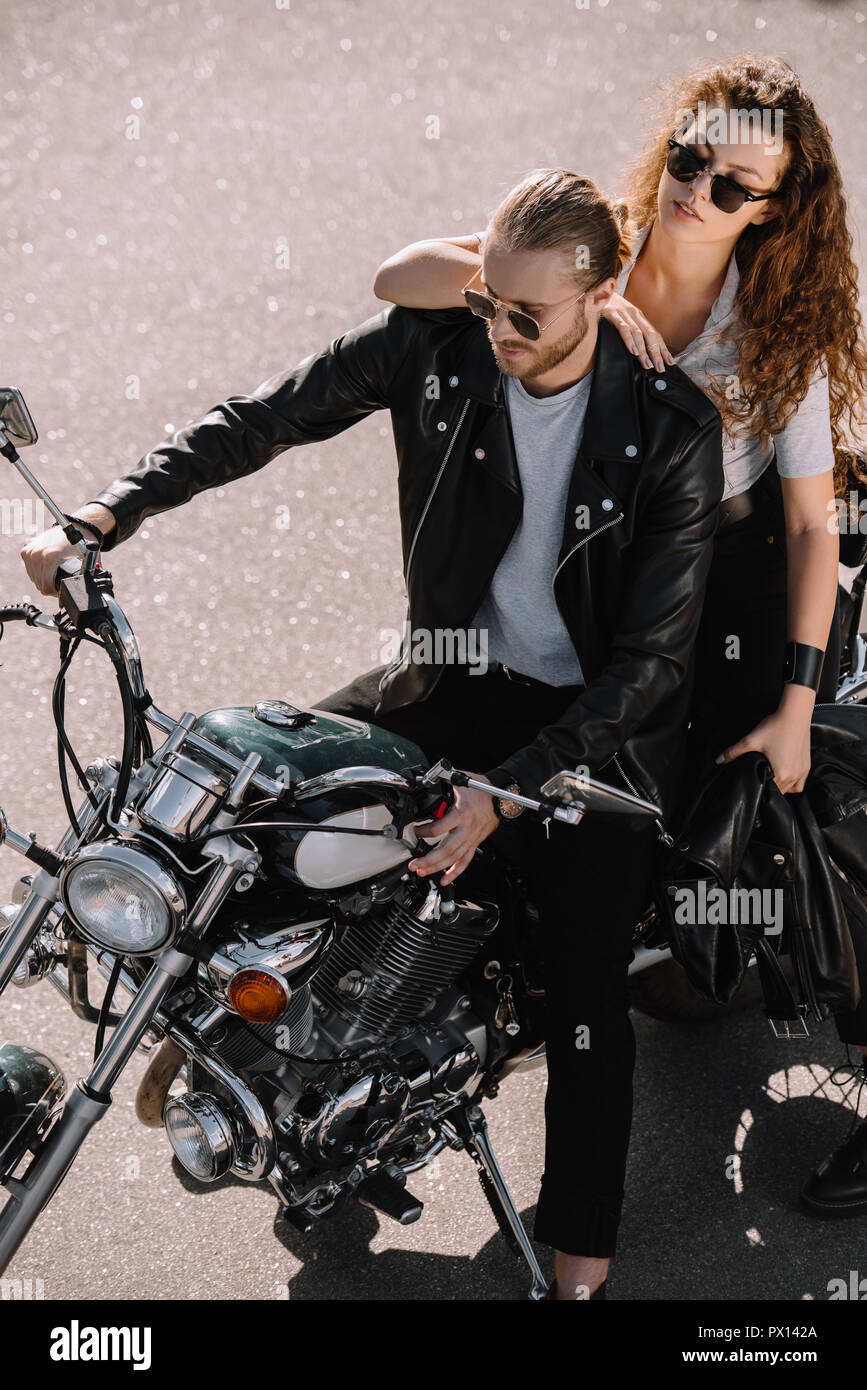 two bikers sitting on classical cruiser motorcycle on asphalt road ...