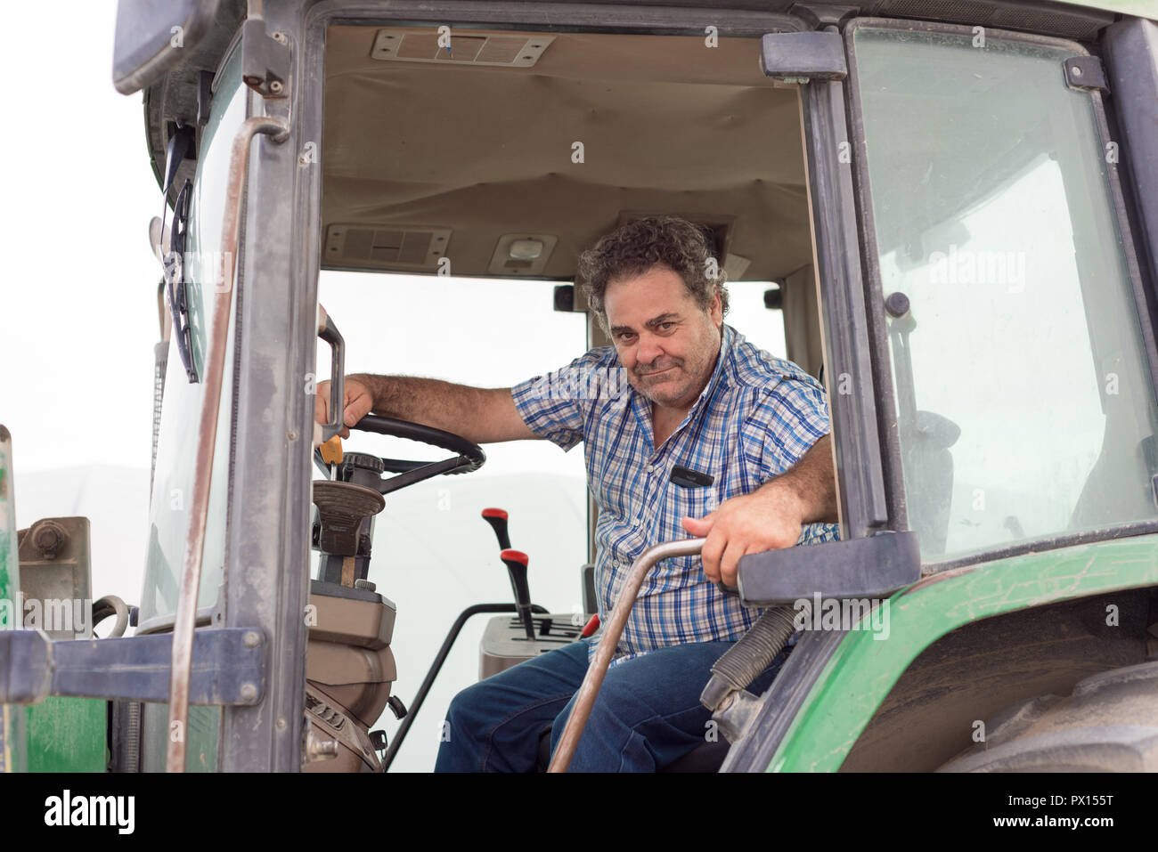 Farmer driving tractor in the countryside Stock Photo - Alamy