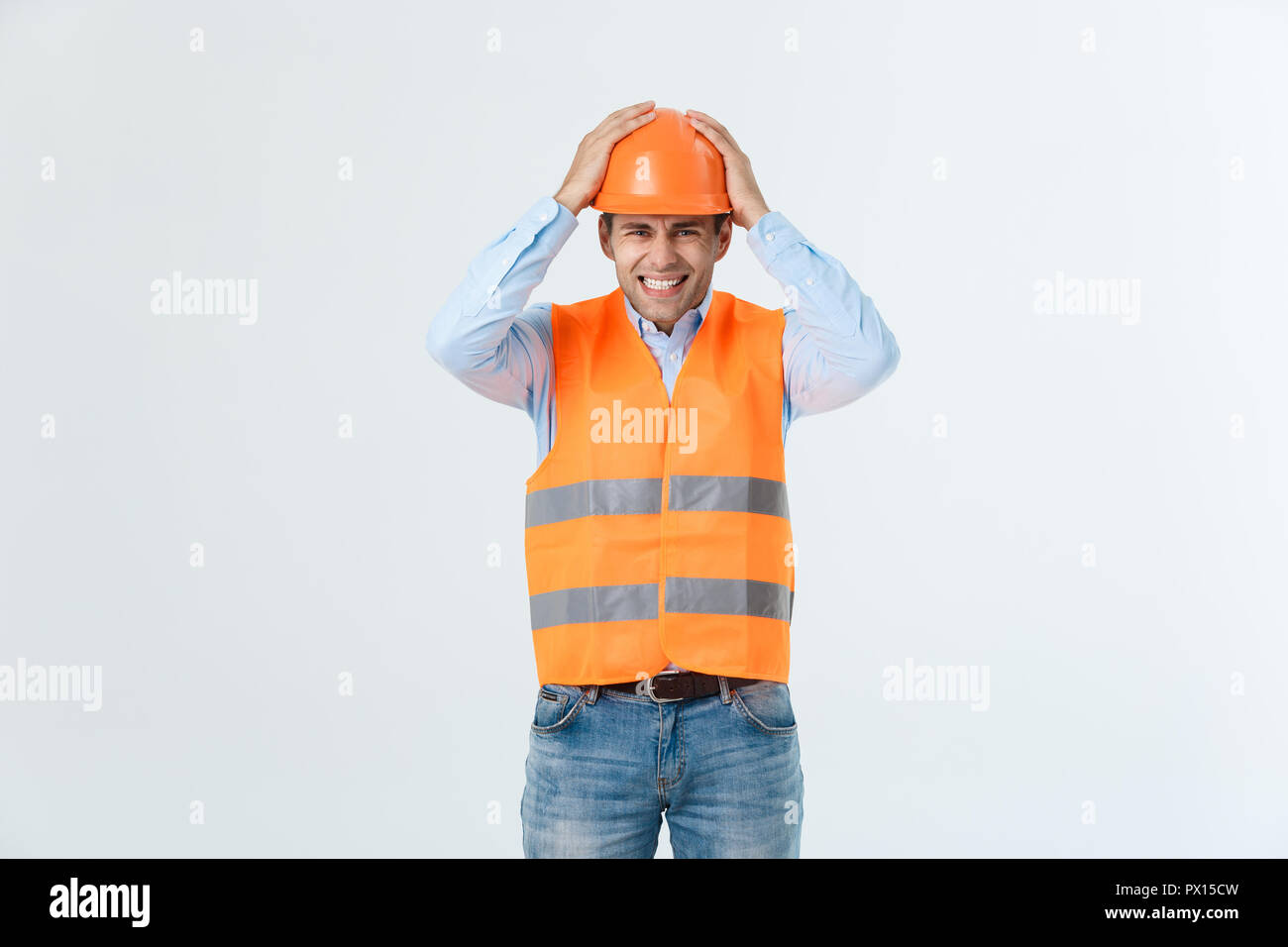 Disappointed handsome engineer wearing orange vest and jeans with ...