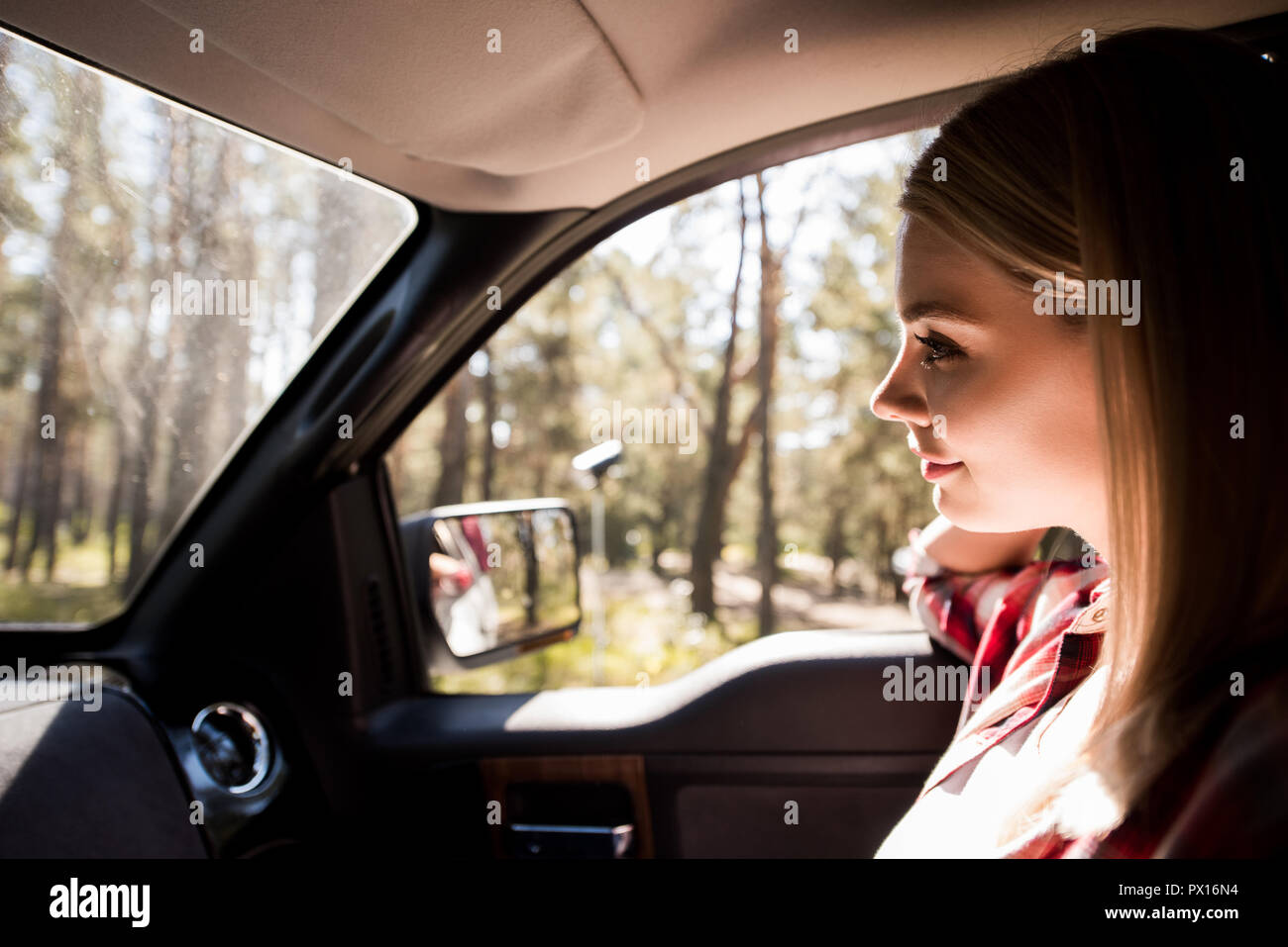 beautiful female driver sitting in car in forest Stock Photo - Alamy