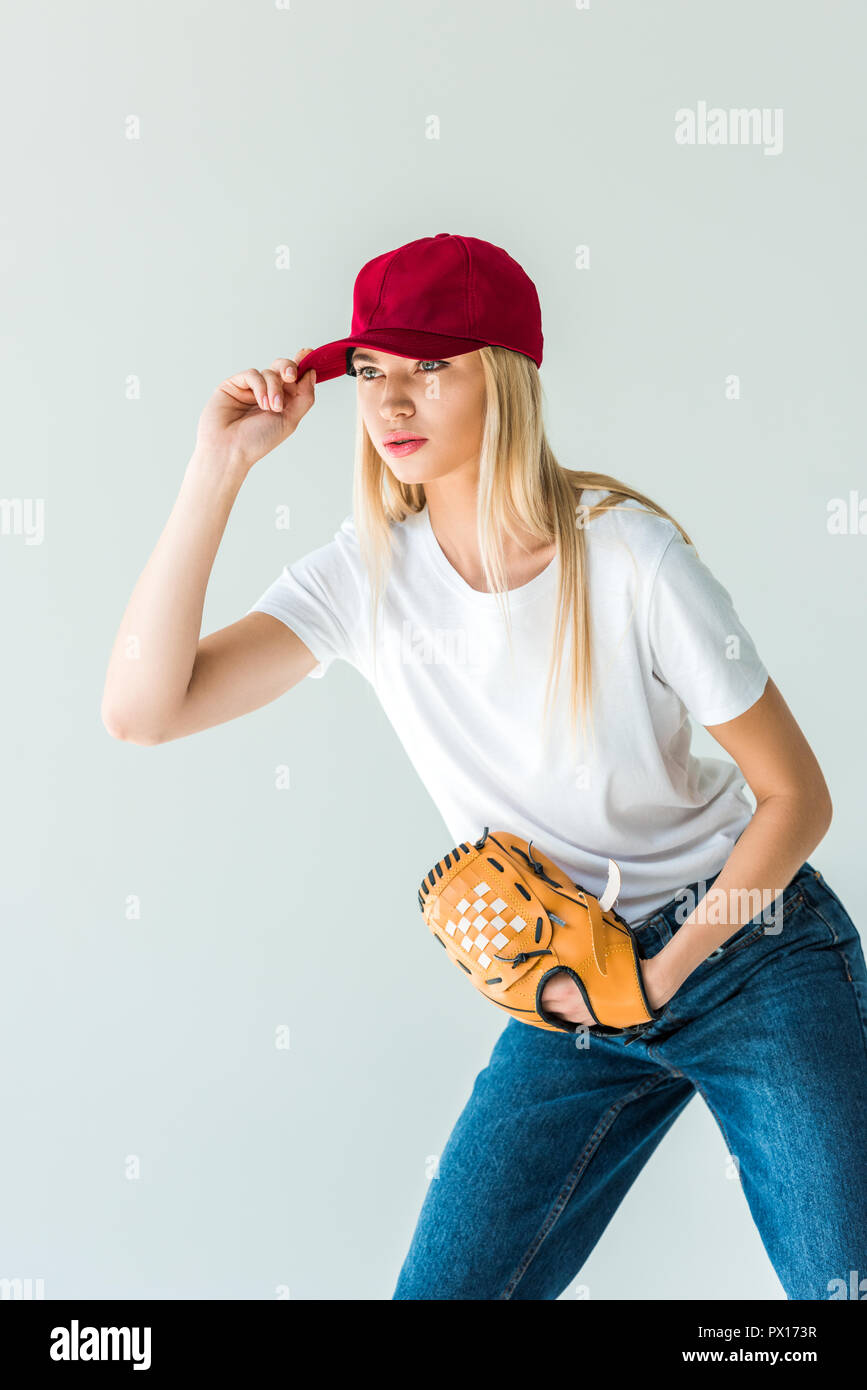 attractive baseball player touching red cap and holding baseball glove ...