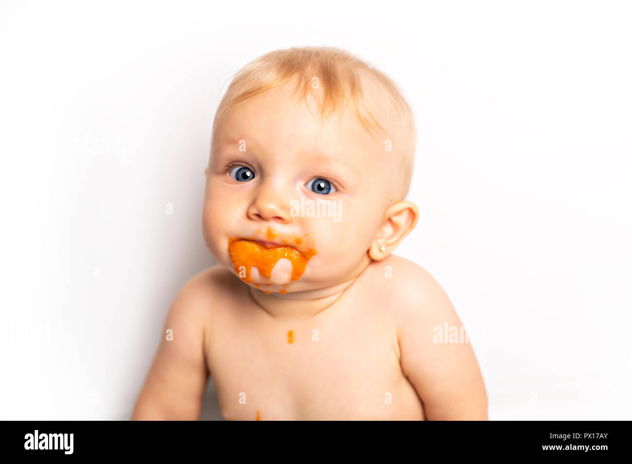 An Adorable baby girl making a mess while feeding herself Stock Photo ...