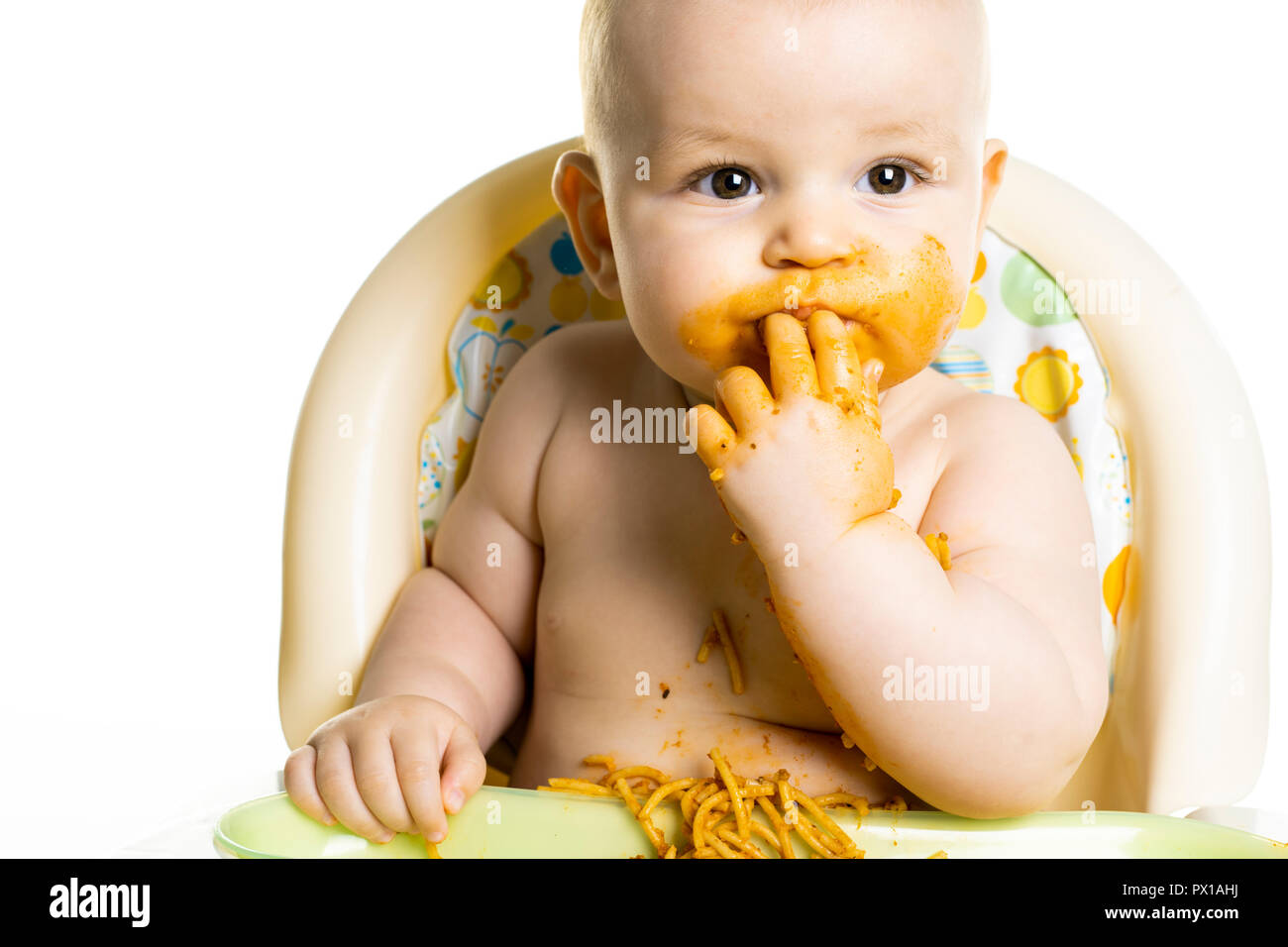Little baby eating her dinner spaghetti and making a mess on his face ...