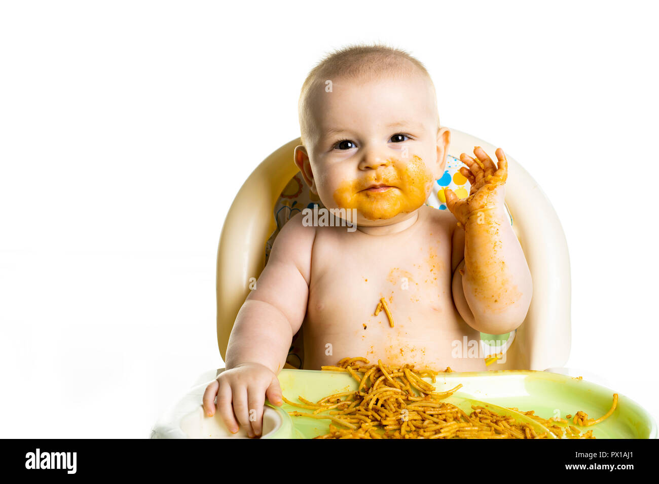 Little baby eating her dinner spaghetti and making a mess on his face ...