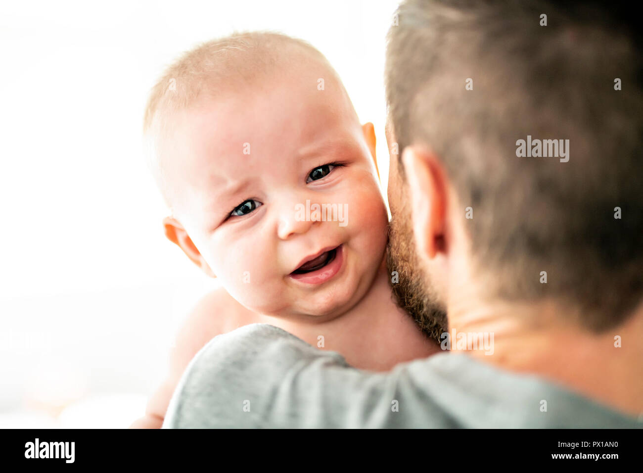 family father with baby boy in front of window Stock Photo - Alamy
