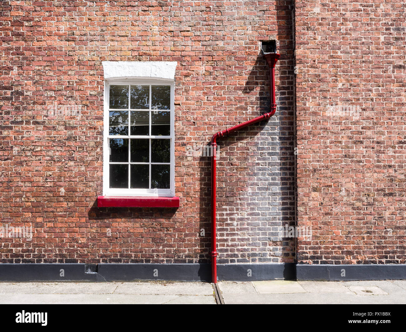 Brick wall with window and gutter in Manchester Stock Photo - Alamy