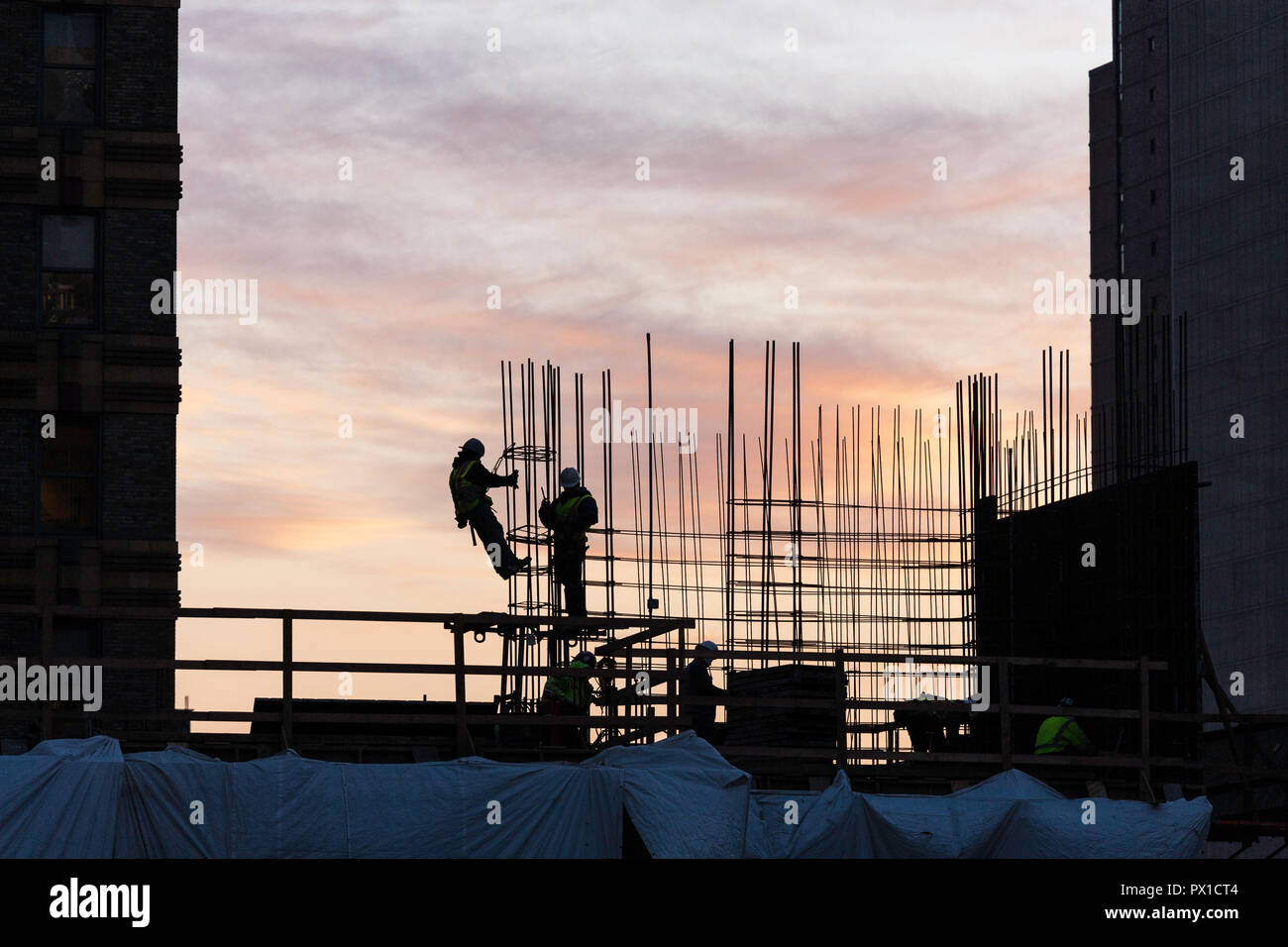 Silhouettes of high-rise construction workers on site, Midtown ...