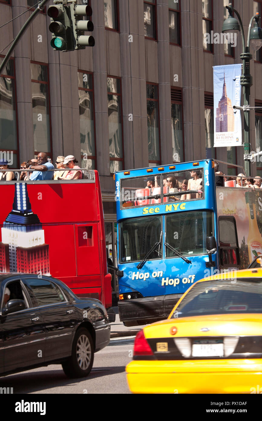 Multi-colored tour buses and taxi cab in Midtown Manhattan, USA Stock ...