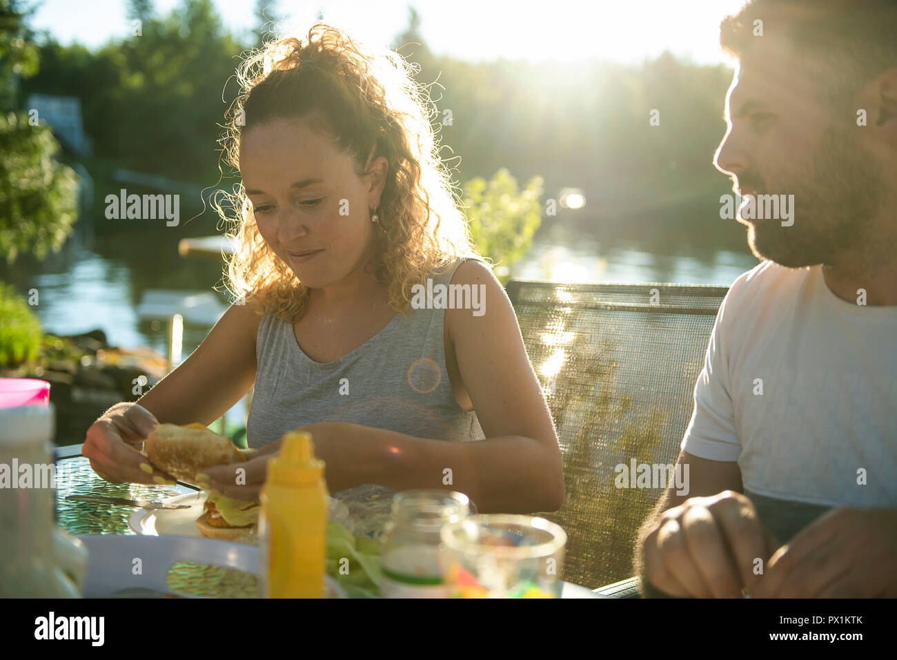 mother eating hamburger outside with his family Stock Photo - Alamy