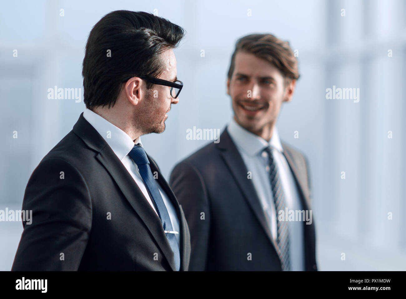 business partners are talking standing in the office hall Stock Photo ...