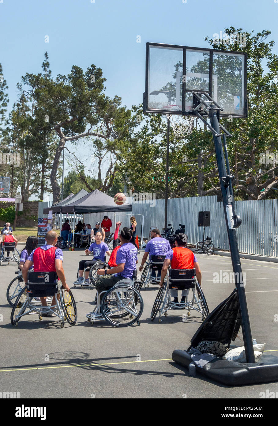 Multiracial handicapped members of a wheelchair basketball team play a ...
