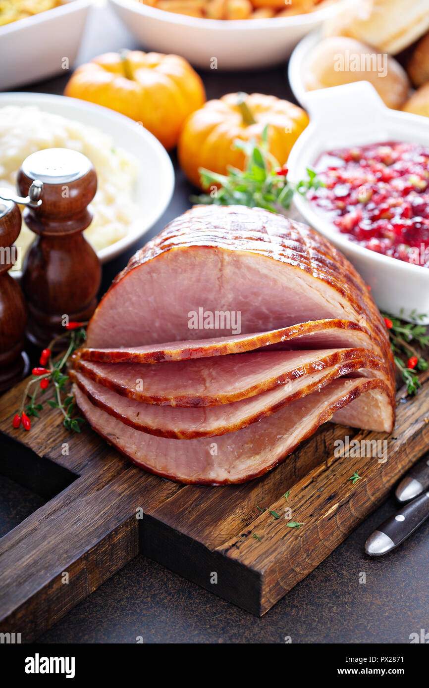 Holiday glazed sliced ham on dinner table for Thanksgiving or Christmas ...