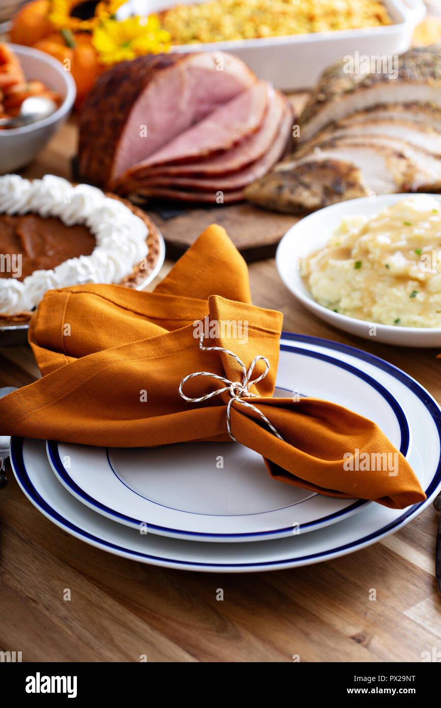 Thanksgiving table with roasted turkey, sliced ham and side dishes ...