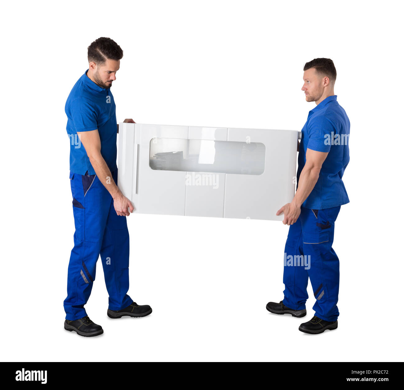 Side View Of Two Male Movers Holding Furniture On White Background ...