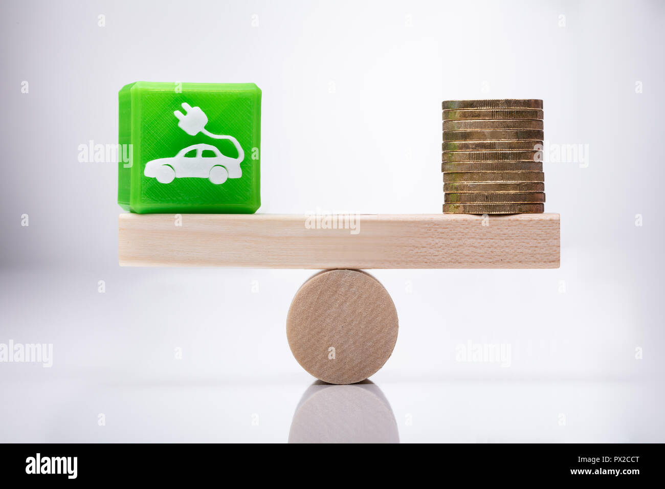 Green Eco Car Icon Cubic Block And Coins Balancing On Wooden Seesaw ...