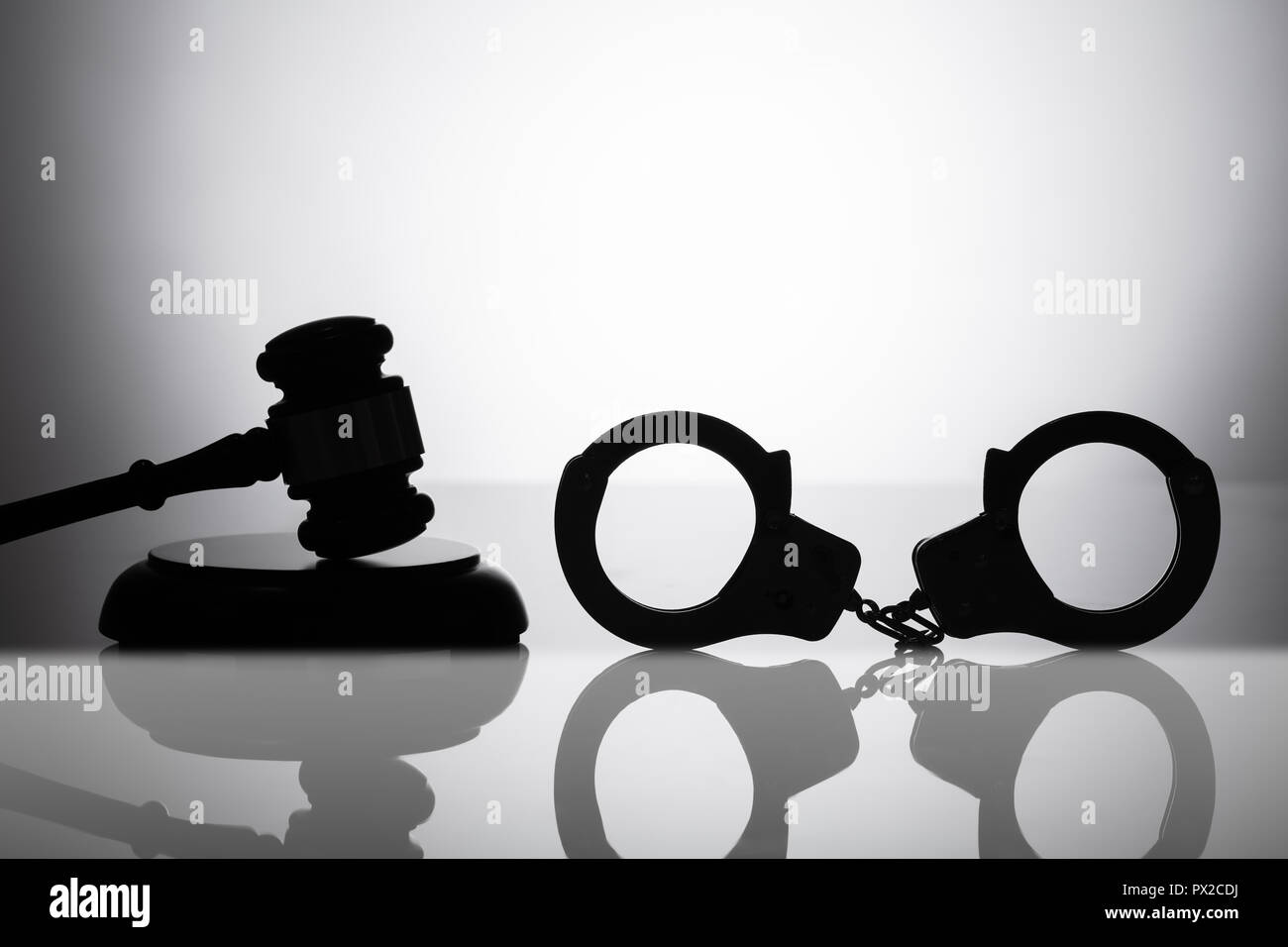 Silhouette Of Handcuff Near Gavel With Sounding Block On Reflective ...