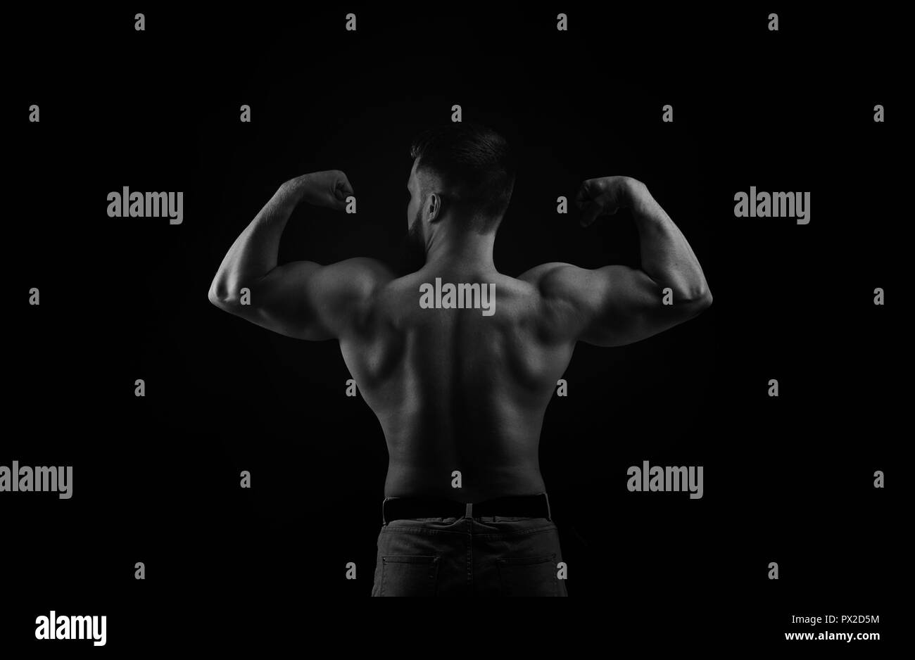 Bodybuilder black and white portrait. Muscular man stands back and ...