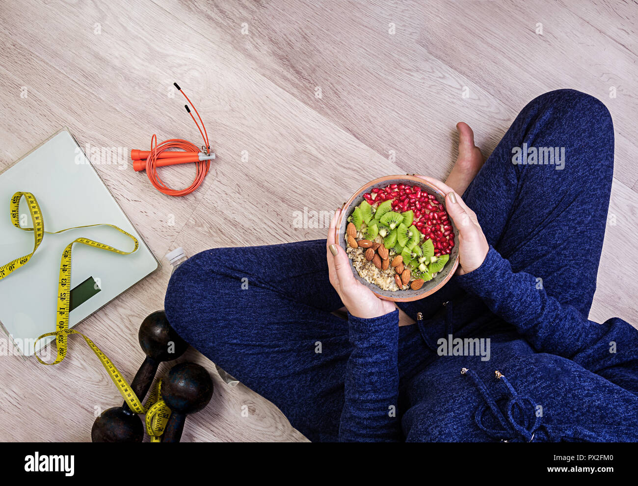 Fitness and healthy lifestyle concept. Female is resting and eating a ...