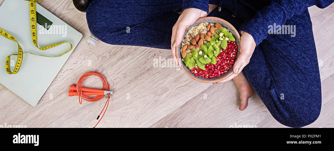 Fitness and healthy lifestyle concept. Female is resting and eating a ...