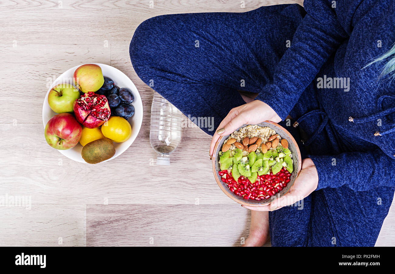 Fitness and healthy lifestyle concept. Female is resting and eating a ...
