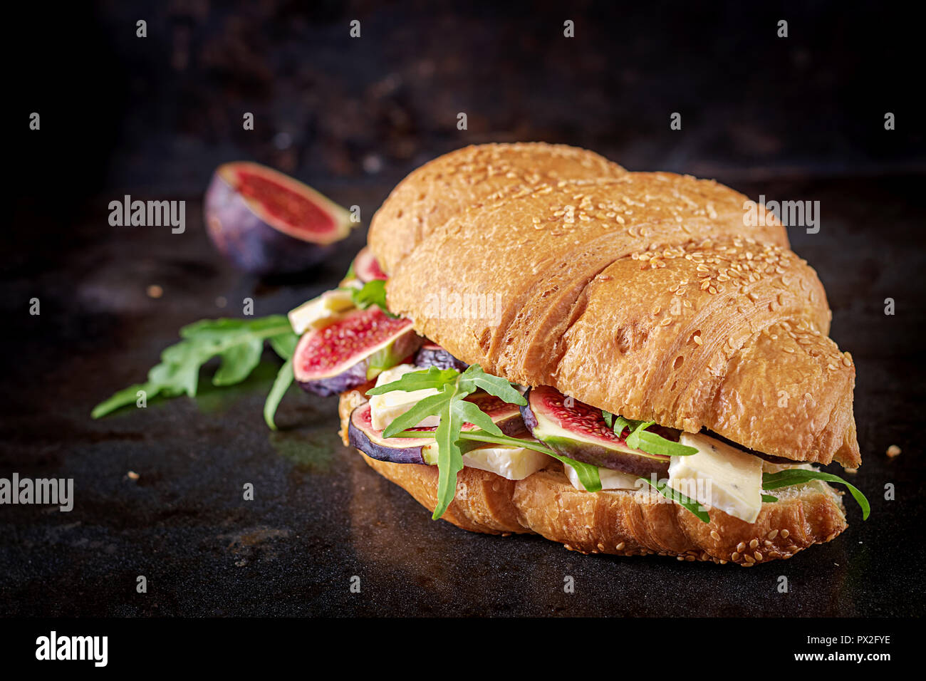 Fresh croissant sandwich with brie cheese arugula and figs. Delicious ...