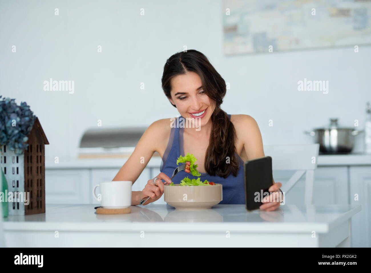 a beautiful young woman is using an application in her smart phone ...