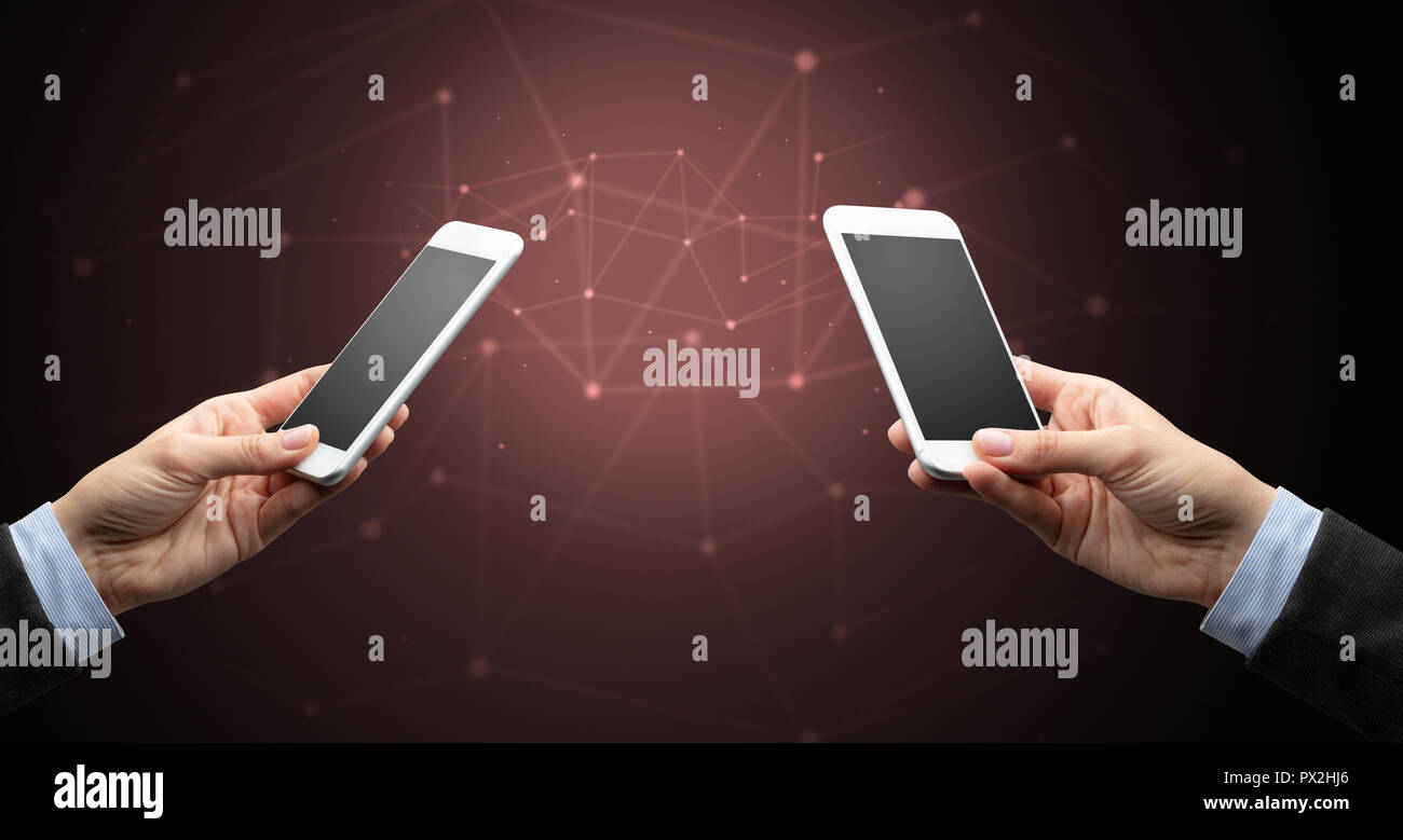 Close up of two hands holding smartphones to each other, wireless ...