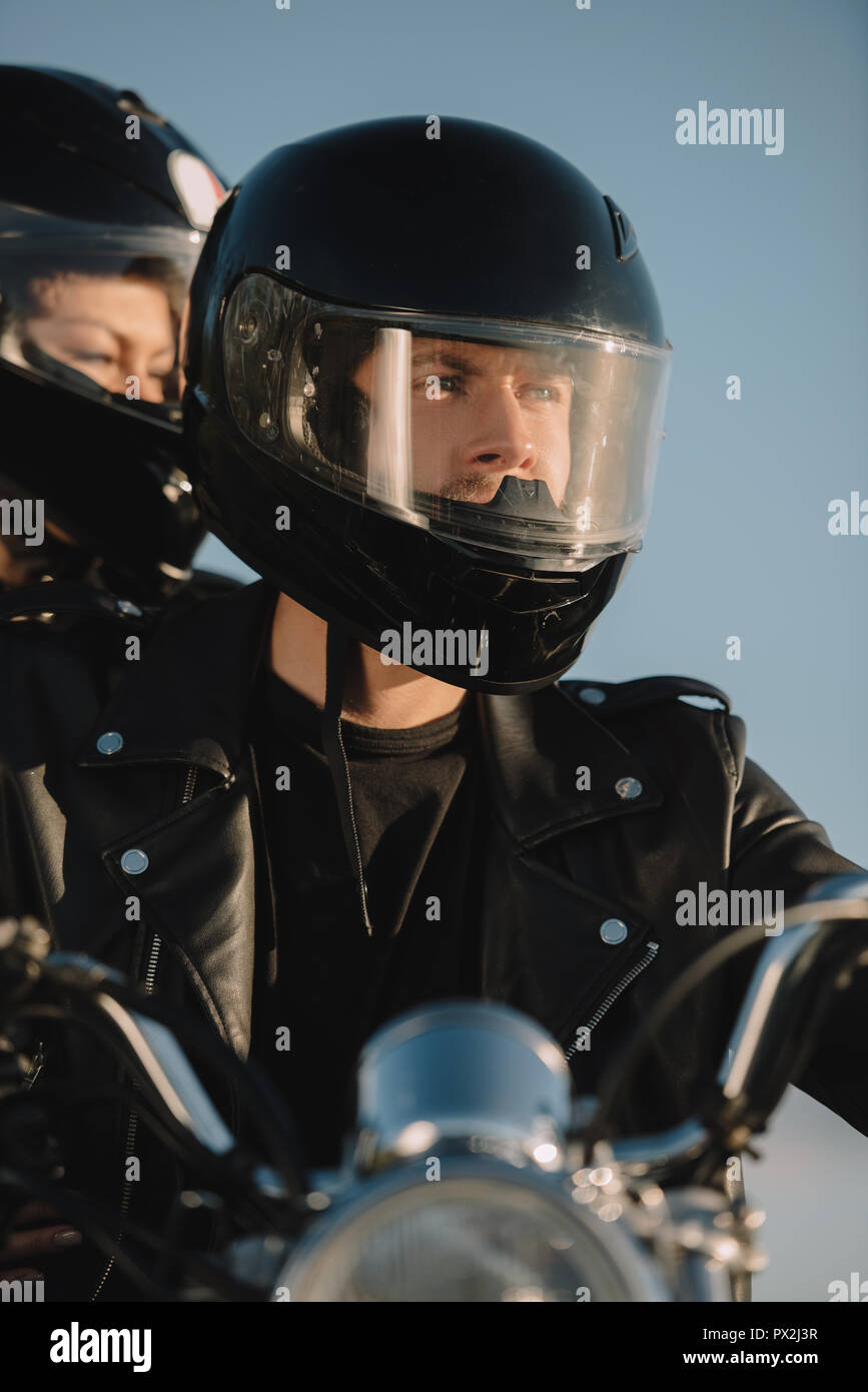 two bikers in moto helmets sitting on motorcycle Stock Photo - Alamy