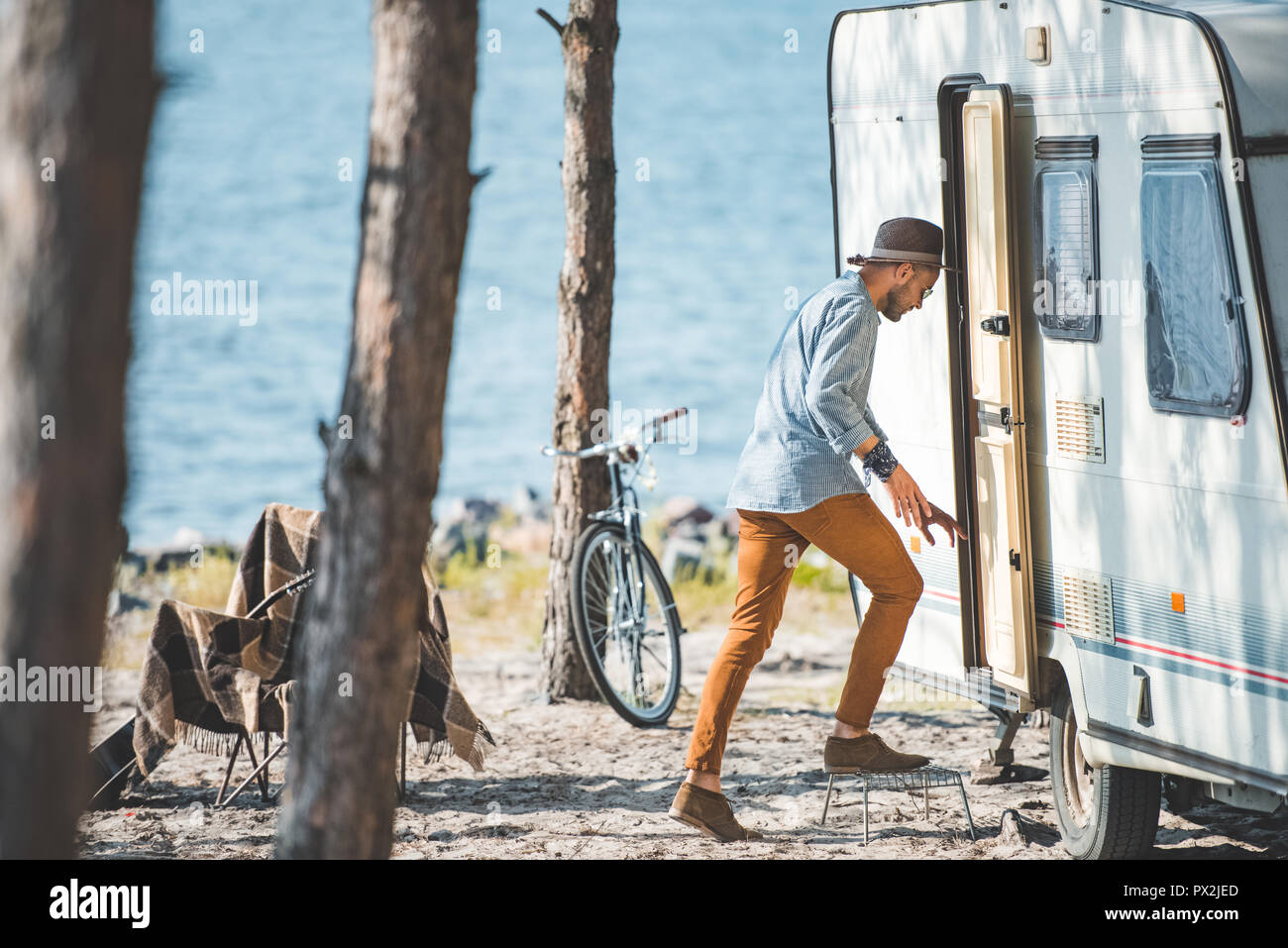 young man going into trailer in camp with bicycle near the sea Stock ...