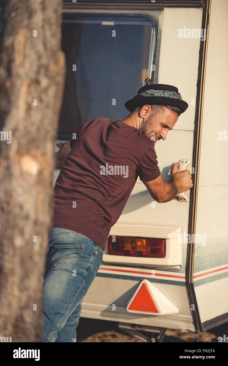 back view of handsome man pushing trailer Stock Photo - Alamy