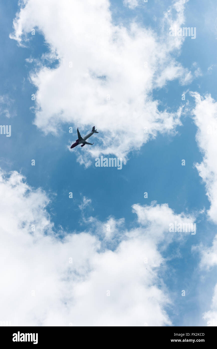 airplane flying in blue cloudy sky during daytime Stock Photo - Alamy