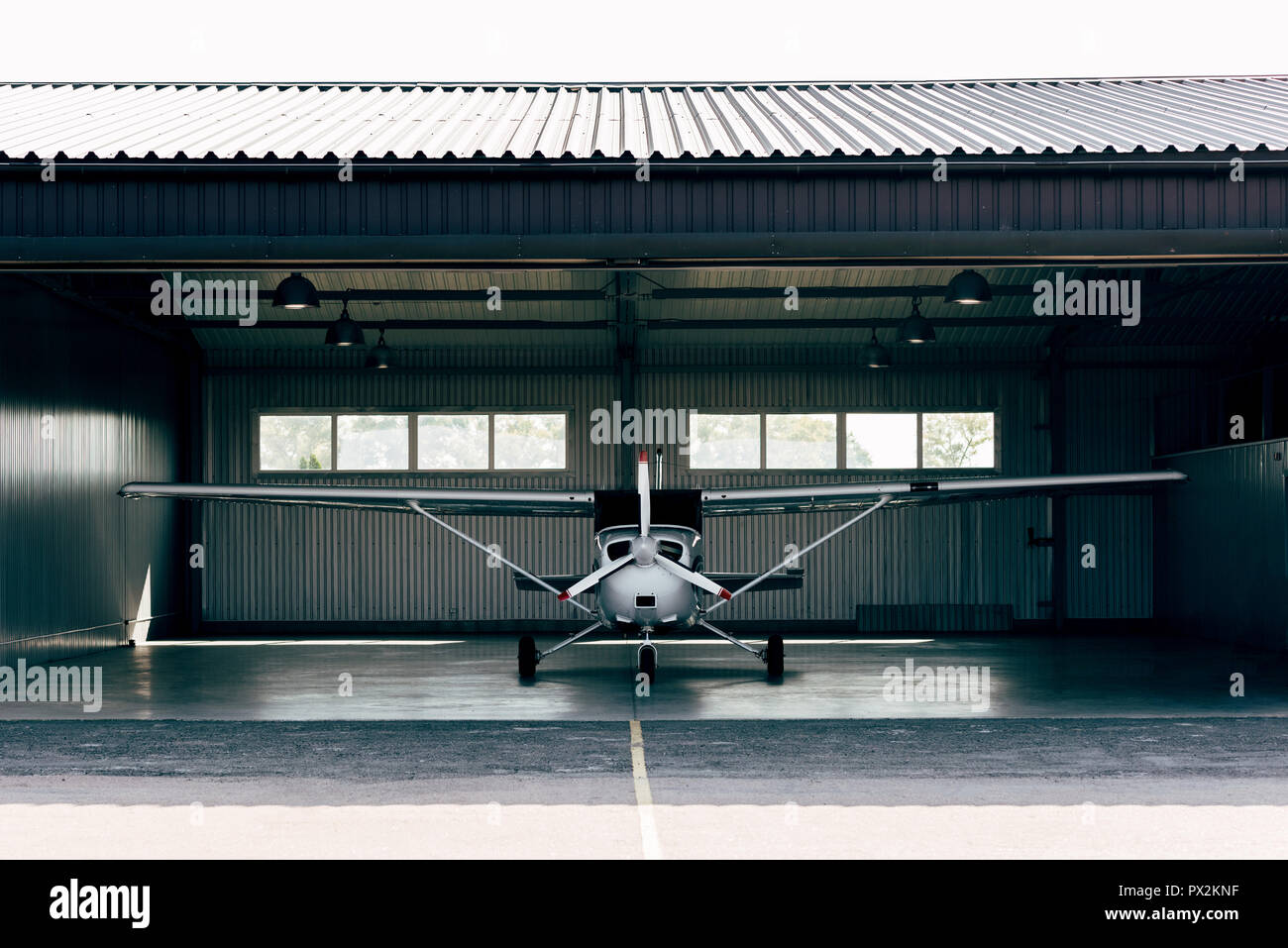 small modern white airplane standing in hangar Stock Photo - Alamy