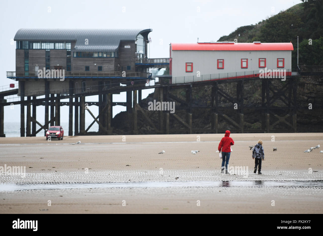 Two people walk towarsds the Tenby RNLI lifeboat station in ...