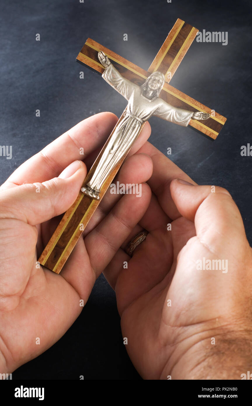 Wood Crucifix Held in Two Hands Vertical Stock Photo - Alamy