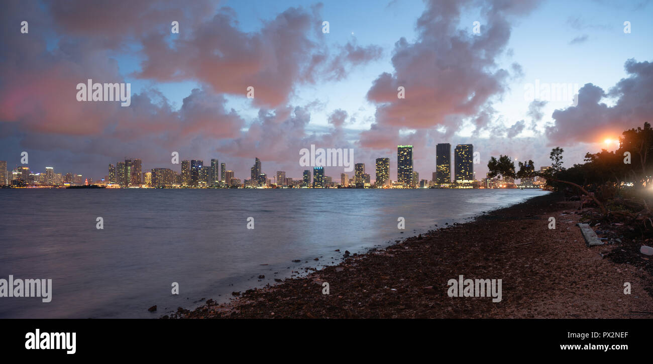 Pink light reflecting off clouds from sunset over the downtown city ...