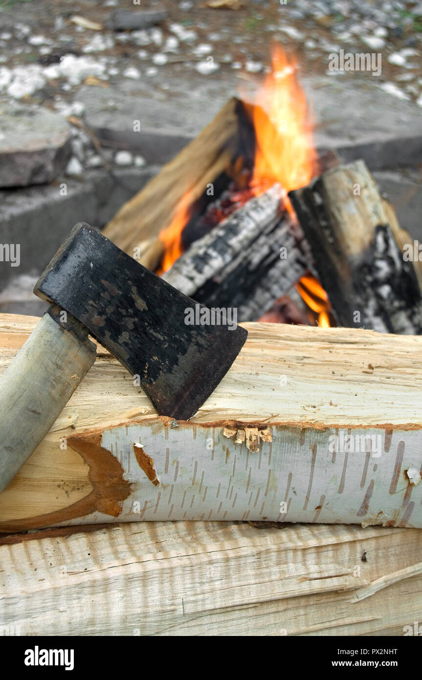 Axe and Firewood Logs in Front of an Outdoor Fire Vertical Stock Photo ...