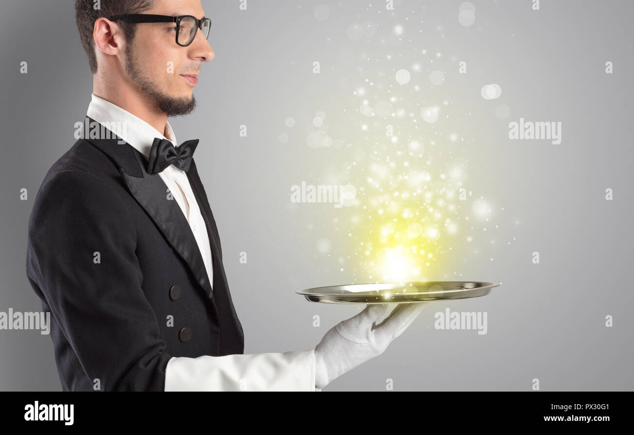 Elegant young waiter serving mysterious light on tray Stock Photo - Alamy