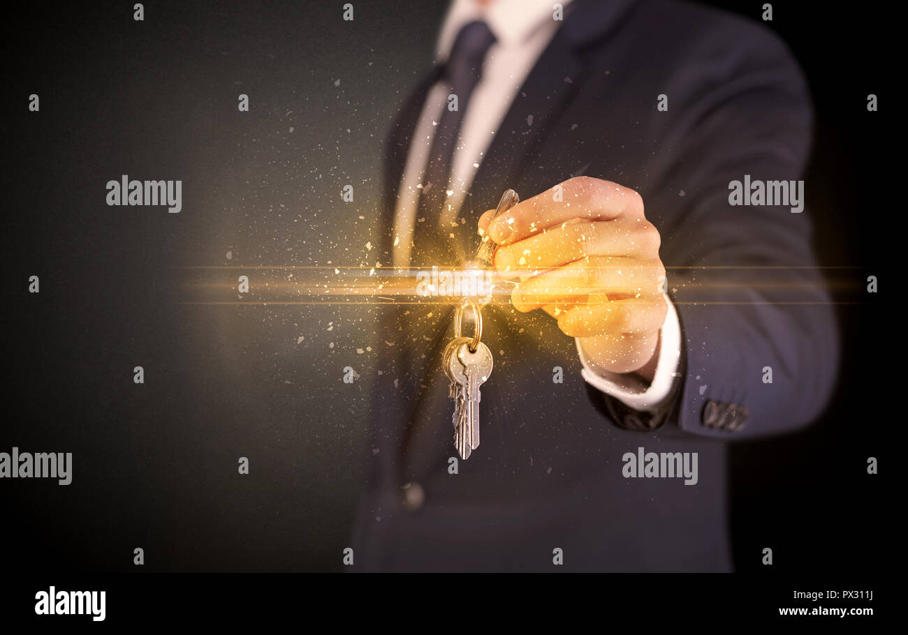 Businessman hand over shiny keys in dark suit with dark background ...