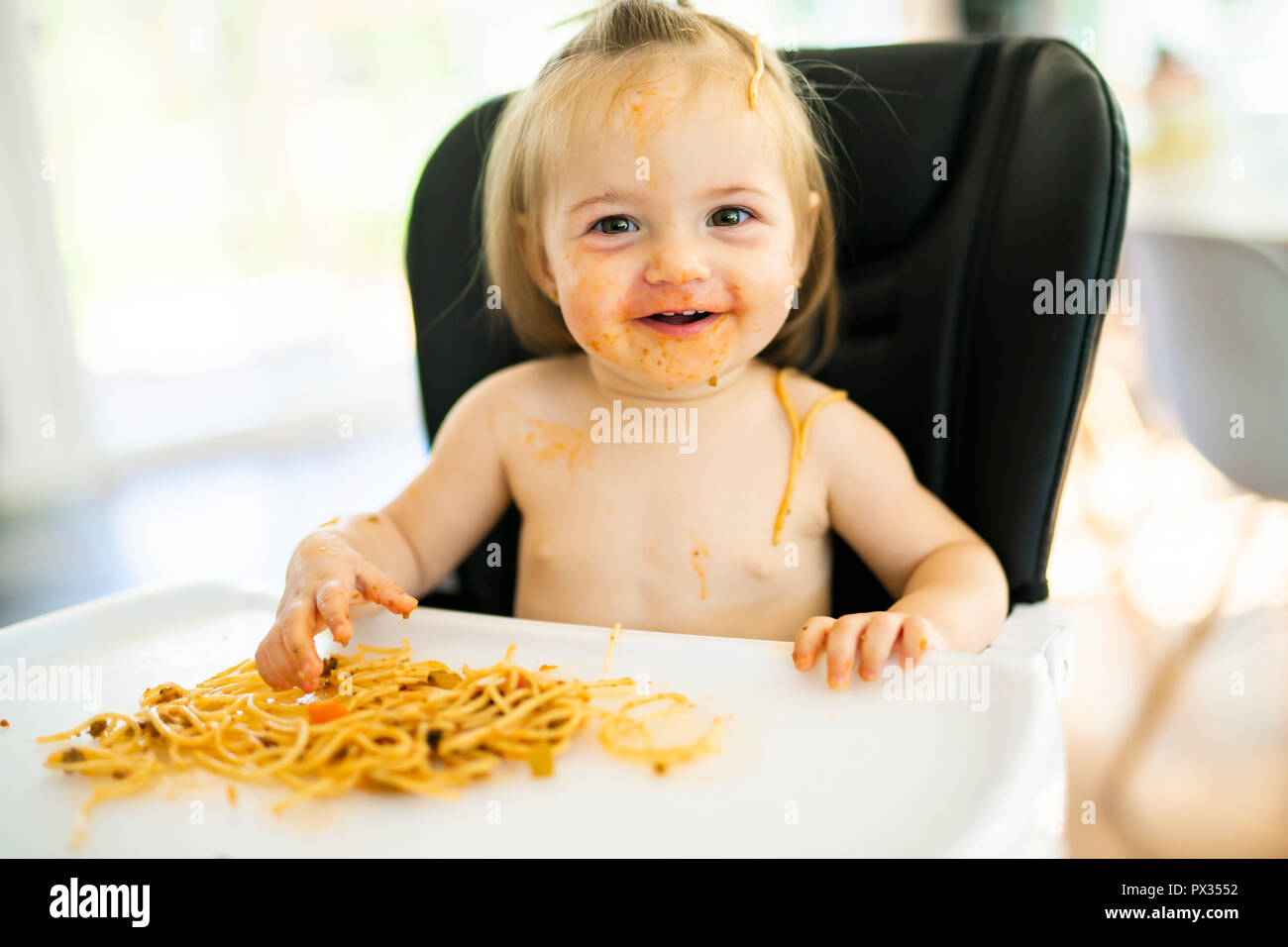 Little b eating her dinner and making a mess Stock Photo - Alamy