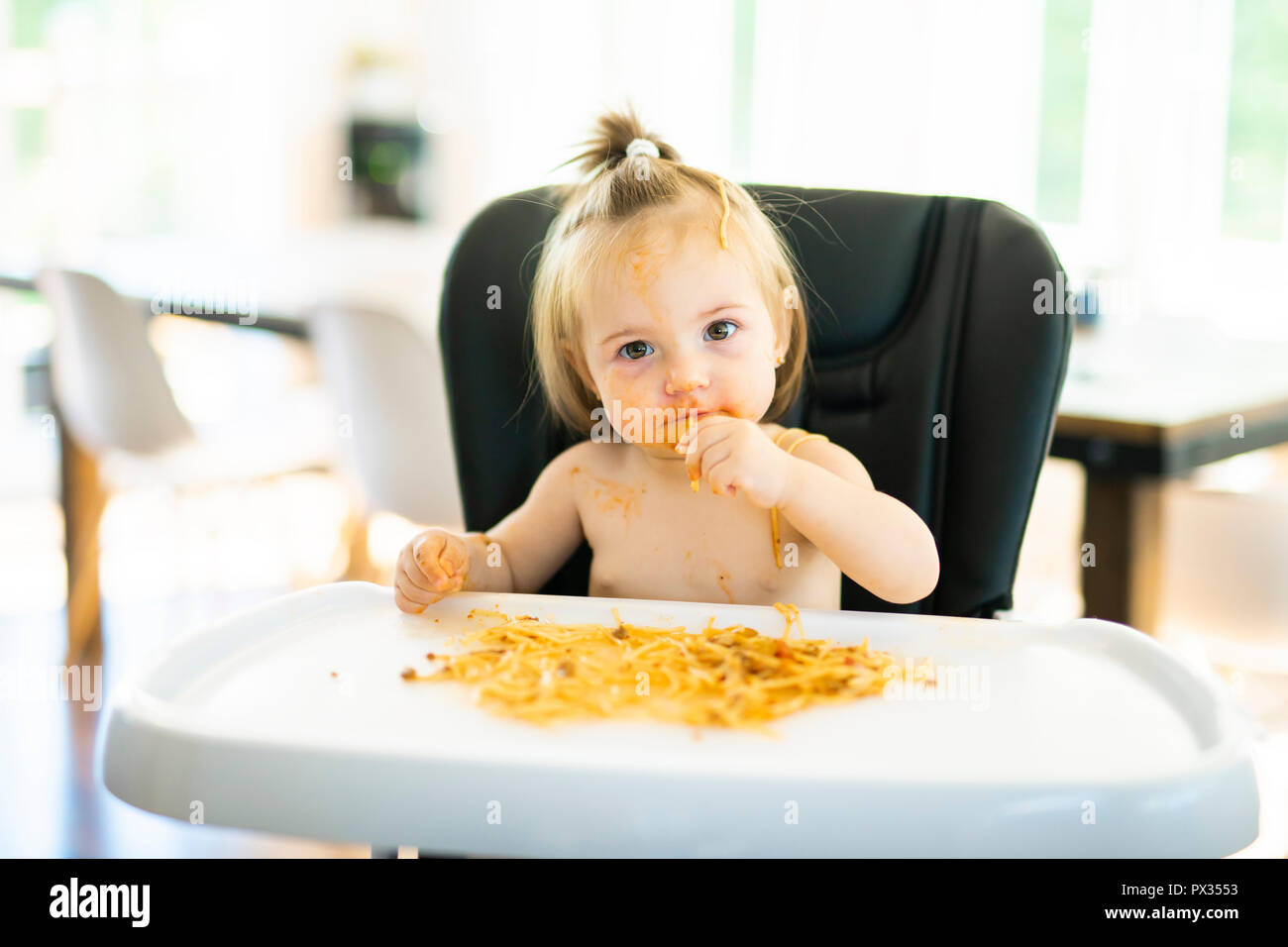 Little b eating her dinner and making a mess Stock Photo - Alamy